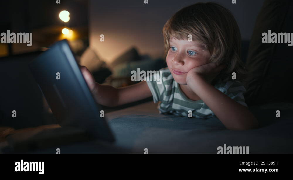 Cute small kid boy in living room using funny editing application on ...