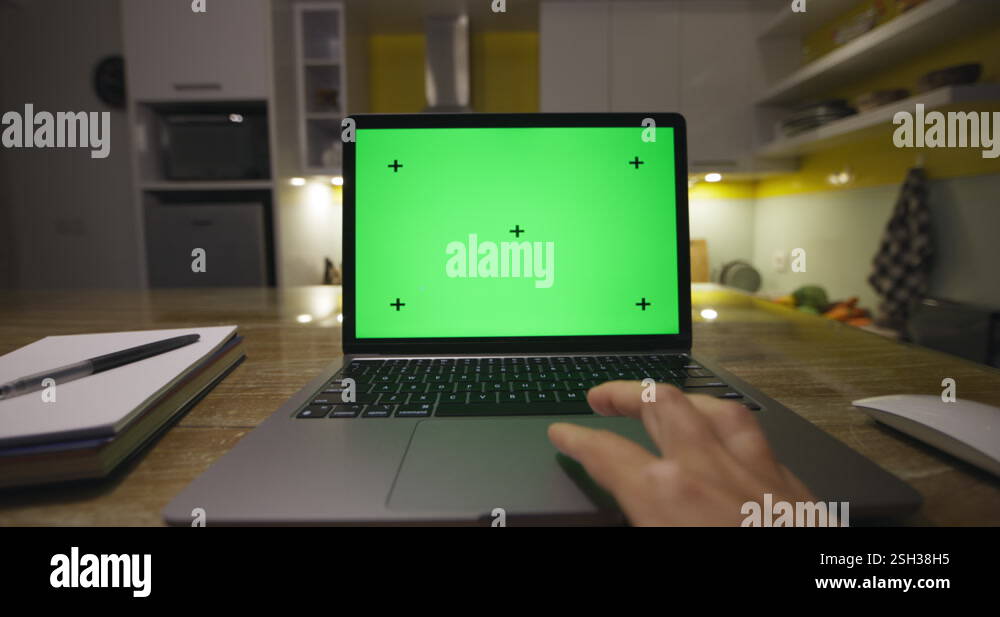 Laptop with green screen. Female hands typing and scrolling on a track ...