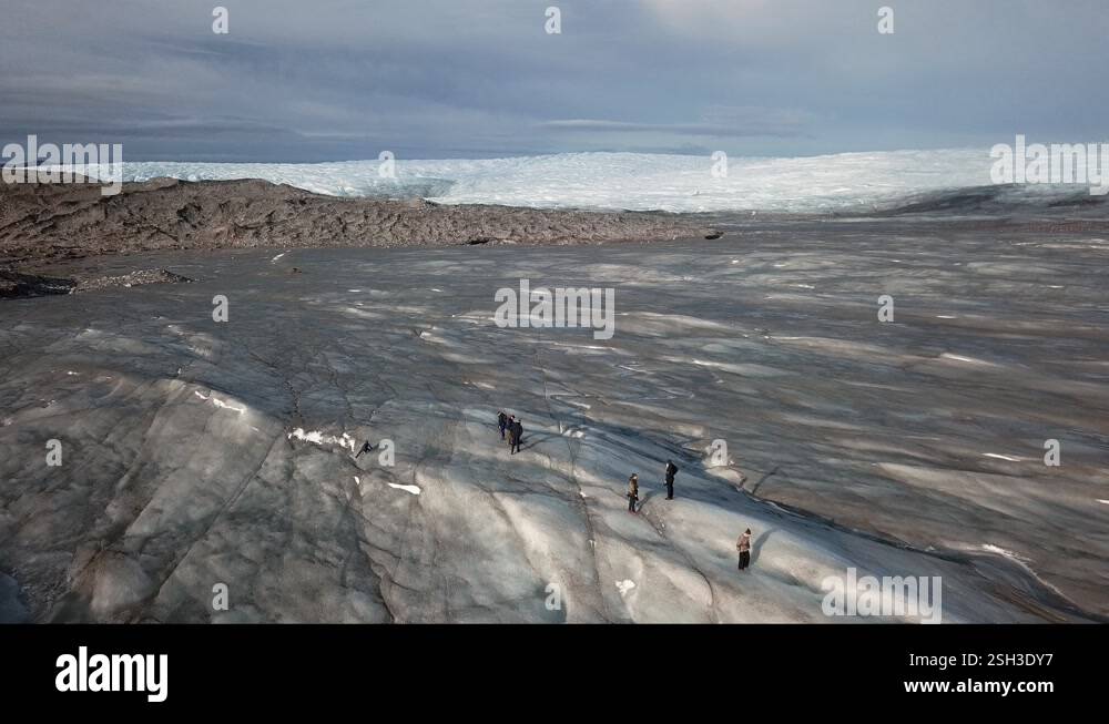 Aerial view, fly over people walking to the left on the icecap at point ...