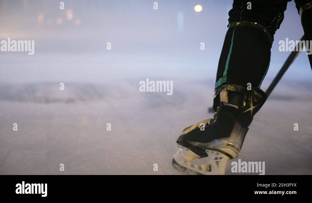 icehockey player takes a dropping puck with his stick and dribble while ...