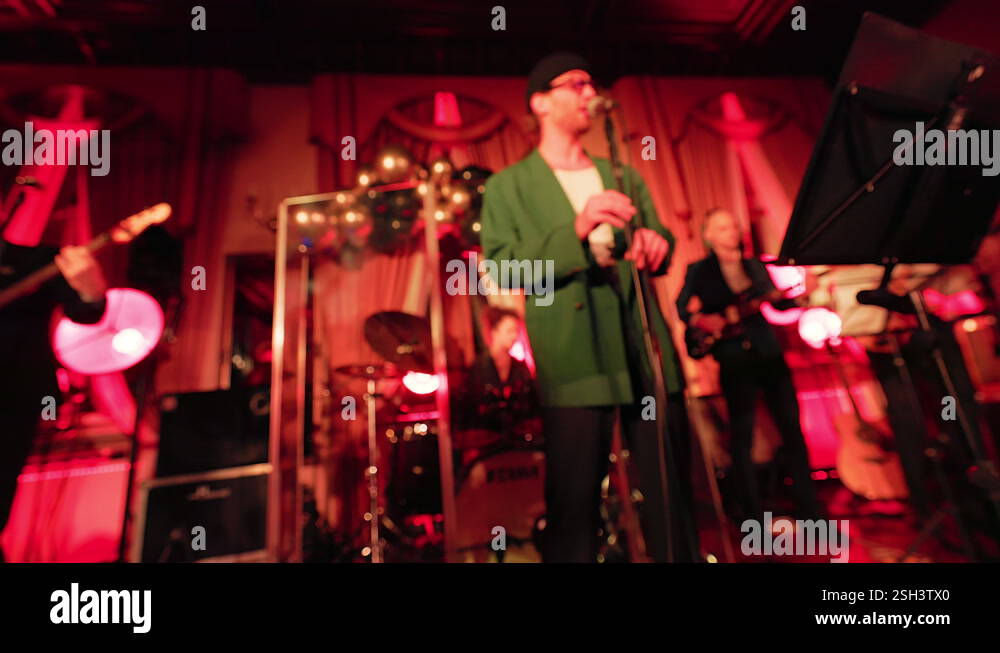 Popular band is performing at a concert with pronounced red colors ...