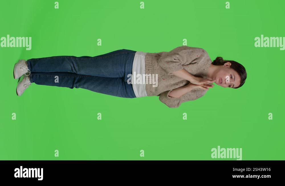 Vertical video: Side view of casual girl doing prayer hands gesture on ...