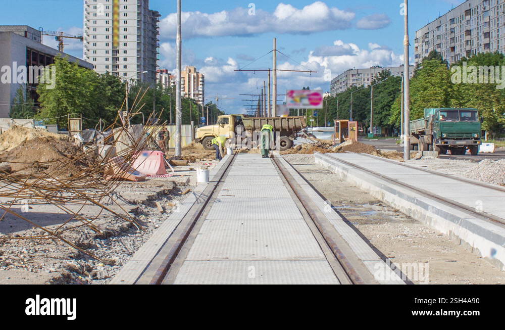 Workers do cleaning of the railway tram line after construction works ...