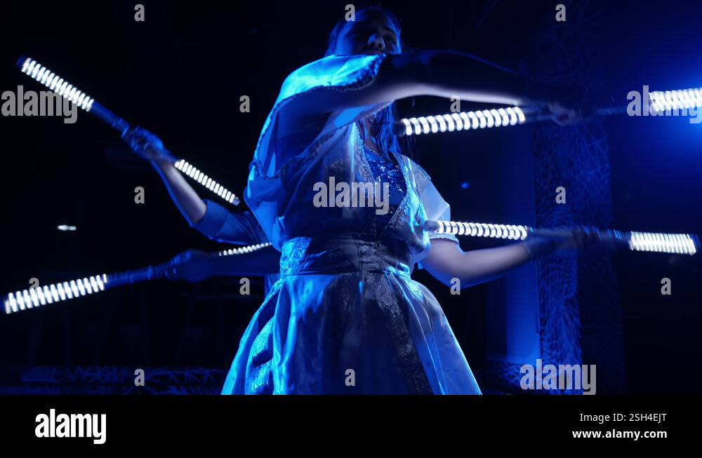 Light LED dance show. Beautiful young girl in a dress and a guy twist ...