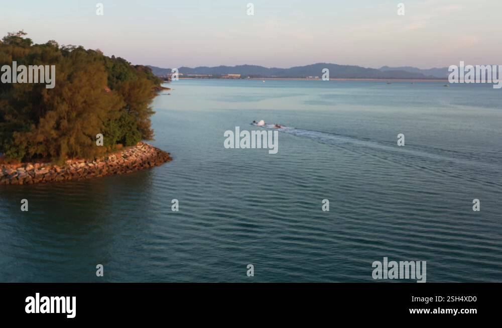 Cinematic aerial drone chasing and following behind a jet ski pulling a ...
