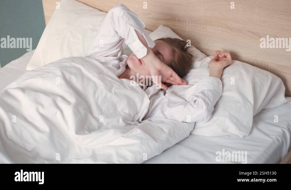 Beautiful red haired woman slowly waking up in the morning and ...
