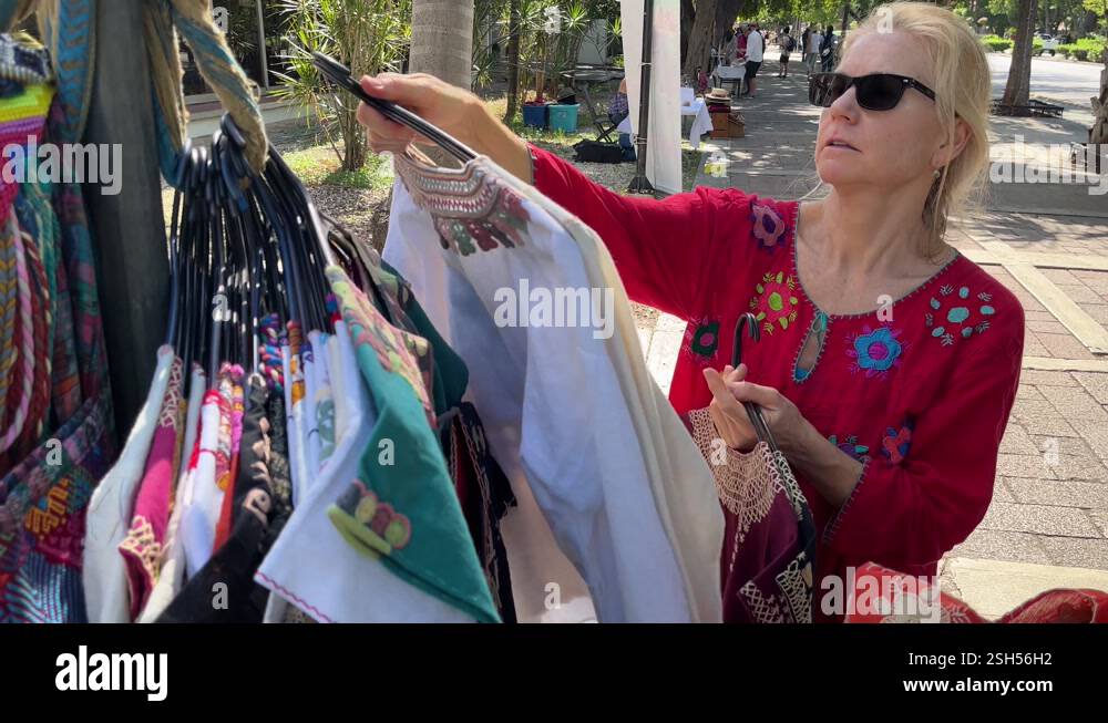 Mature woman tourist shopping for tradition Mayan clothes handicrafts ...