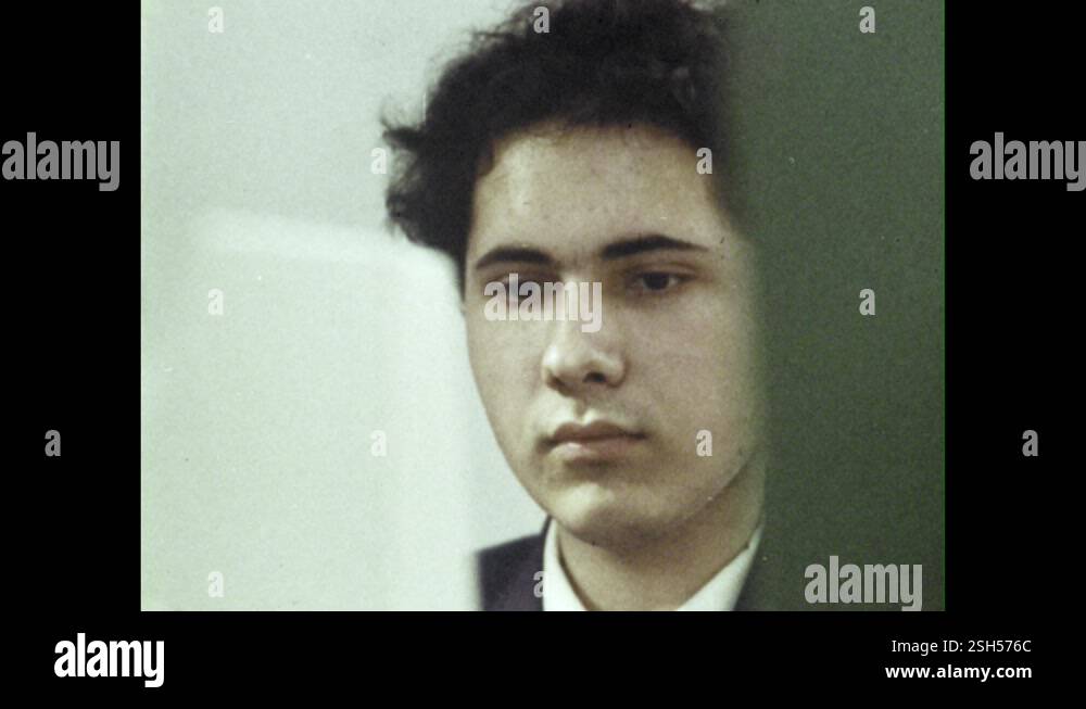 1980s: Boy types on computer in classroom. Text appears over colored ...