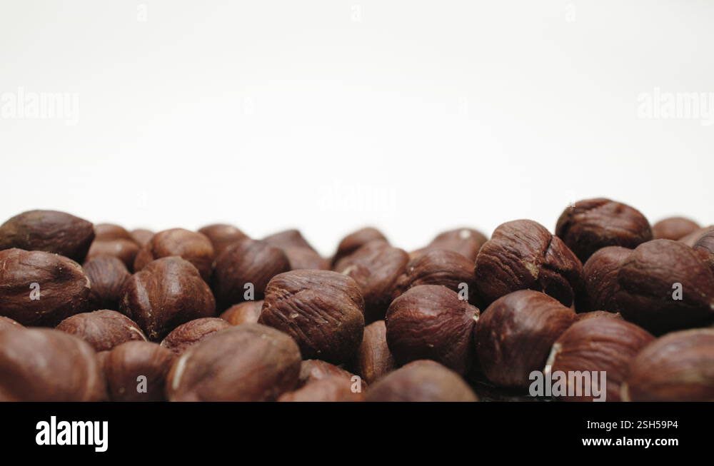 Hazelnuts pile whole nuts white background slide shot. Place title, text or logo Stock Video ...