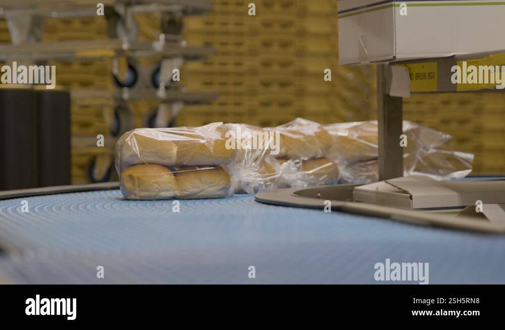 Bread buns in plastic packaging rolling down a conveyor belt Stock ...