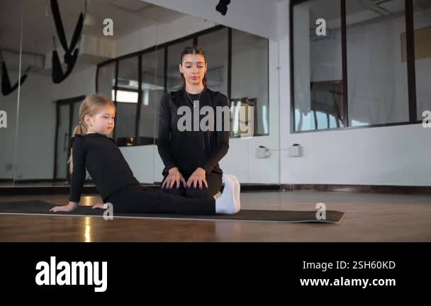 An adult and a child are enjoying practicing yoga poses together to ...