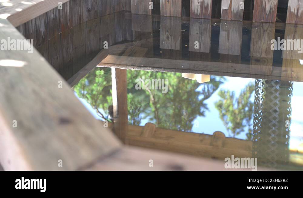 Woodfired hot tub with calm rippling water and reflecting trees from ...