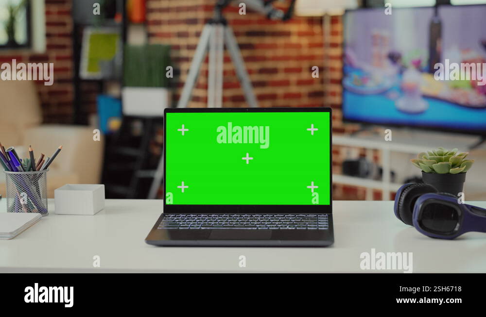 Laptop computer showing green screen isolated display on empty desk ...