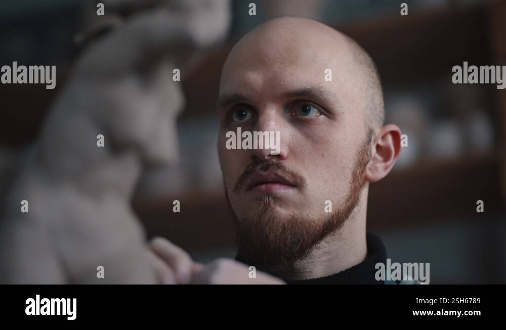Close-up portrait of a master sculptor man making a clay sculpture ...