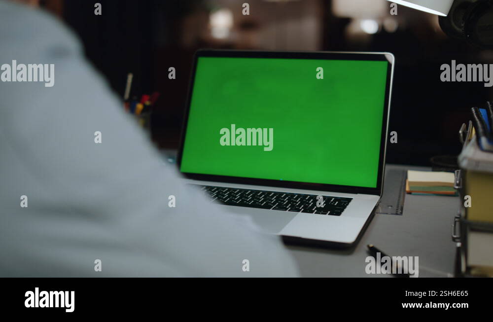 Unrecognizable guy watching mockup laptop home. Man reading green ...