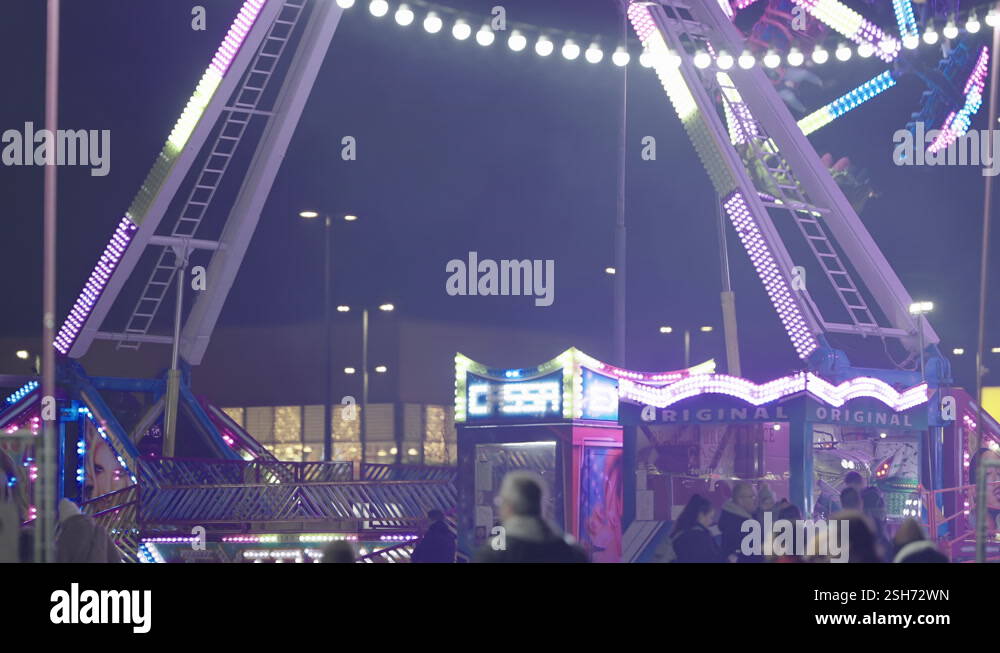 Bright amusement park giant pendulum ride swing above people heads at ...