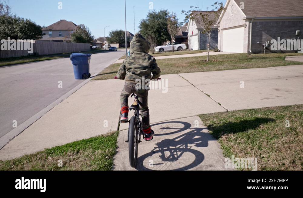 A young boy rides his bike on a sidewalk through his neighborhood in 4k Stock Video Footage - Alamy