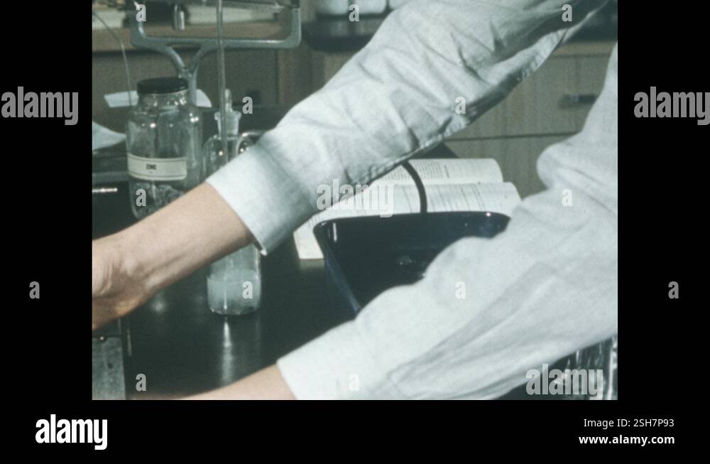 1950s: Person in chemistry class conducts experiment with water, jars ...