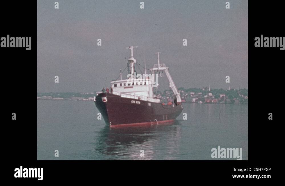 1970s: Sailors stand on bow of cargo ship. Cargo and fishing vessels ...
