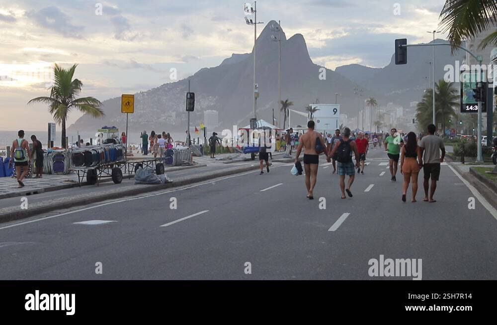Local Brazilian people walking on street next to Copacabana Beach ...