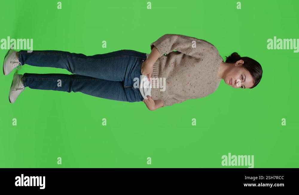 Vertical video: Side view of model posing on full body greenscreen ...
