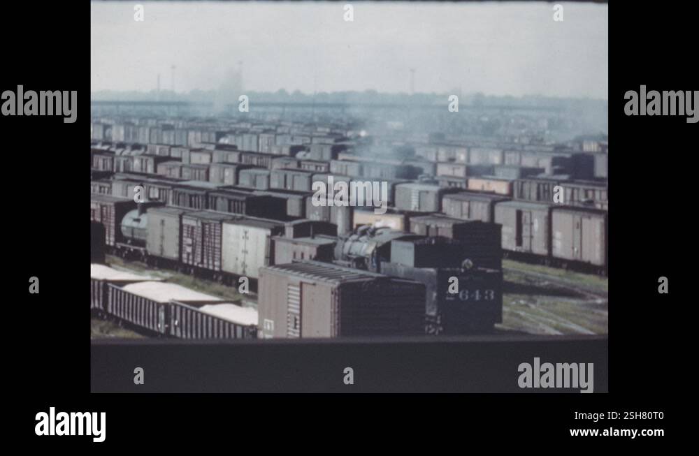 1950s: Freight trains in rail yard. Houses and open green space Stock ...
