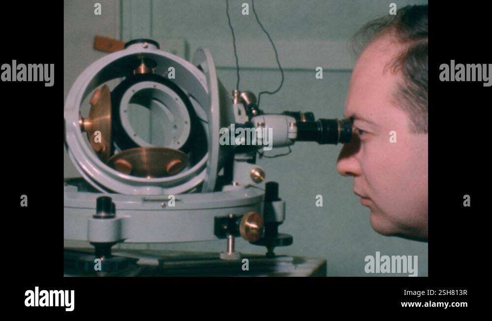 1960s: Man looks through the eyepiece of a multi-axis rotating coil ...