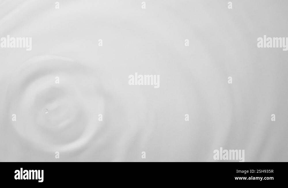 Water drop falling down and making circles on surface. Slow motion ...