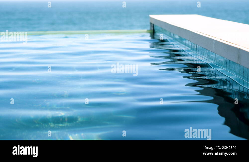 Low static poolside shot of moving surface water of blue swimming pool ...