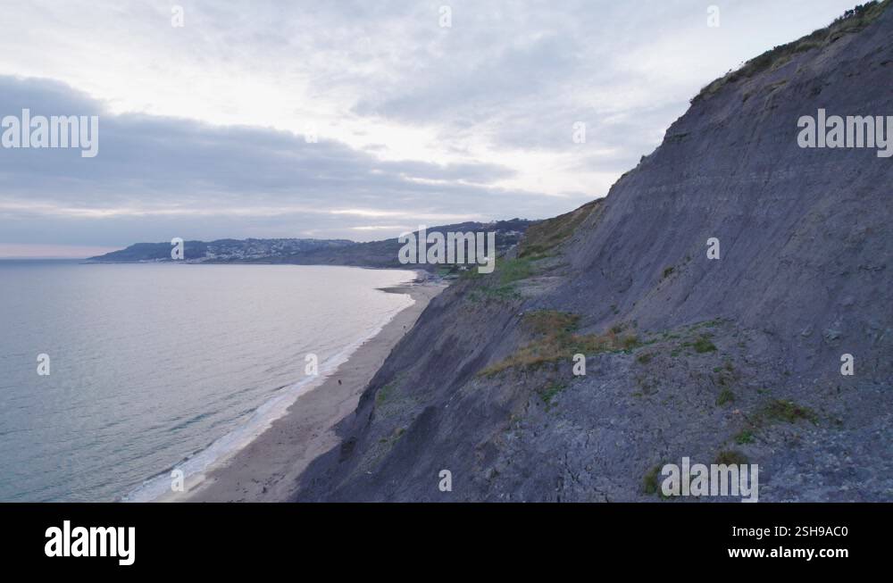 Drone shot flying backwards along a cliff face on the Jurassic Coast ...