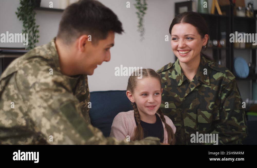 Pretty little girl having fun with loving military parents, happy ...