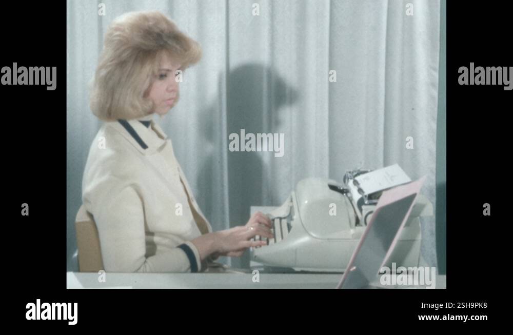 1960s: Side profile of woman sitting at typewriter and touch typing ...