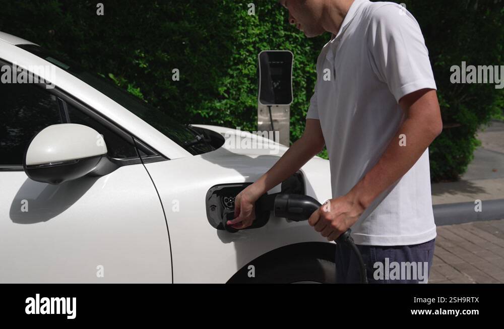 Progressive man install cable plug to his EV car from home charging ...