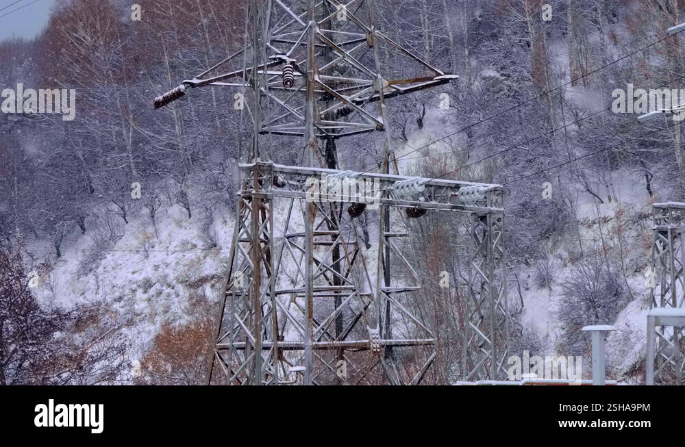 High-voltage wires with insulators on a metal mast near transformer ...