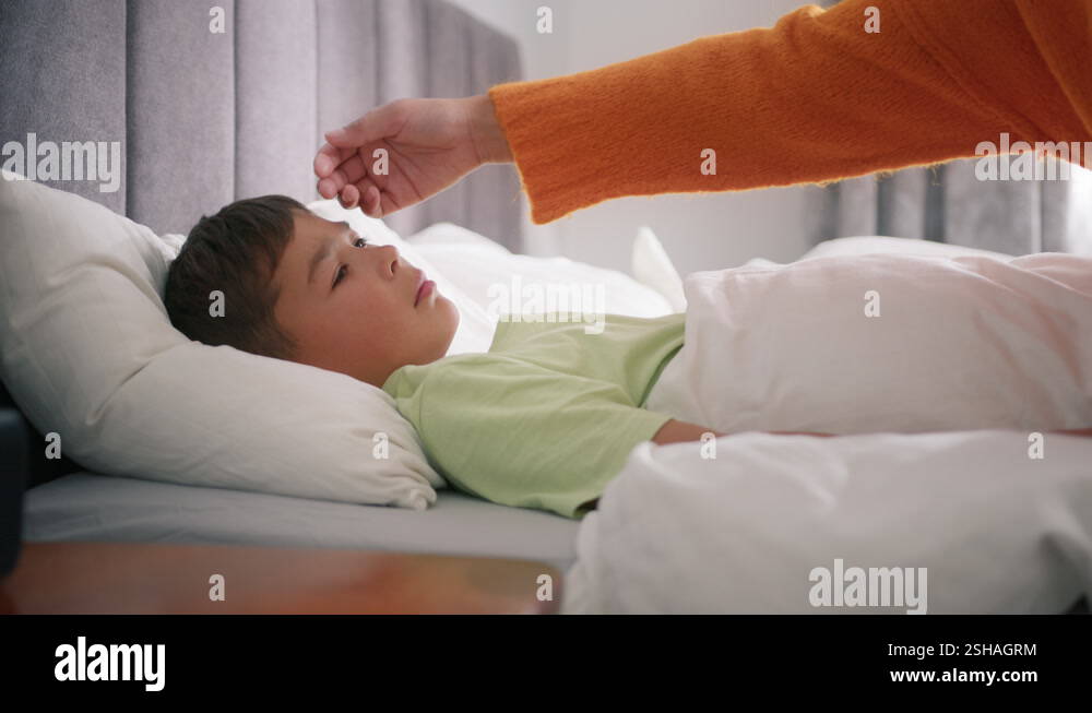 Mother caring for sick boy lying with cough, measuring temperature using hand 4K Stock Video ...