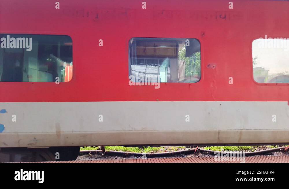 indian passenger express train leaving station on track at evening from ...