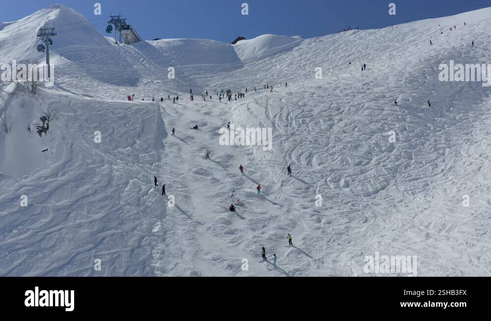 Aerial raising view tourists people riding ski snowboard on slope track ...