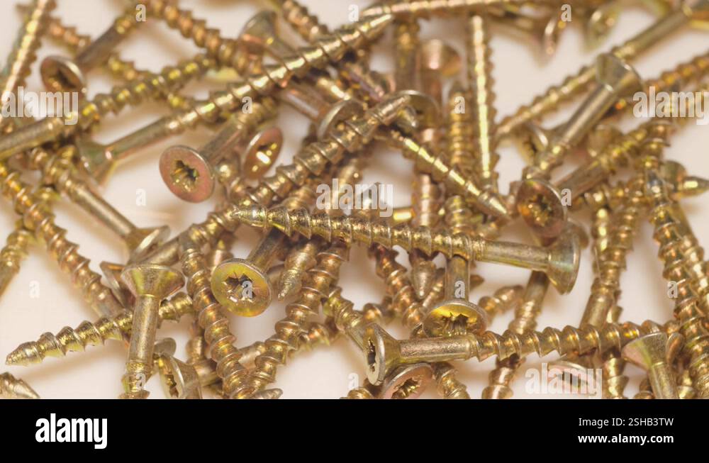 Metal self-tapping screws and screws rotate on the table. Close up ...