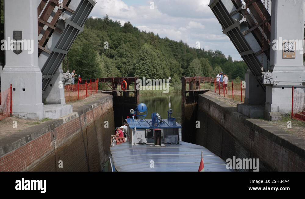Gates of water lock are manually opened. Ship with tourists begins to ...