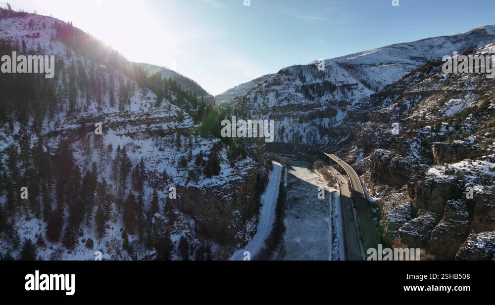 Aerial above narrow valley and two way highway in Rocky Mountains Stock ...
