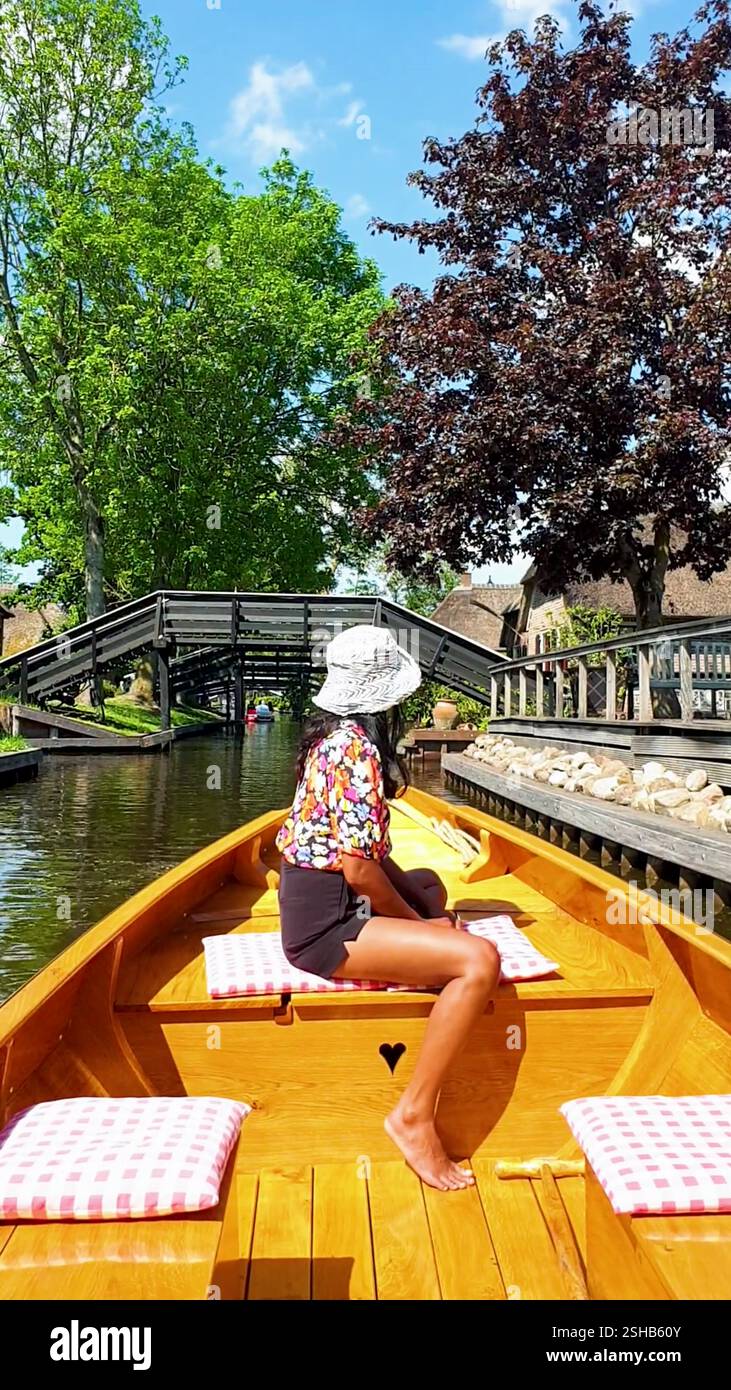 Asian women in wooden boat at the canals of the Dutch village Giethoorn ...