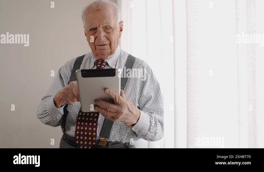 Old man in retirement using modern tablet, tapping touchscreen and ...