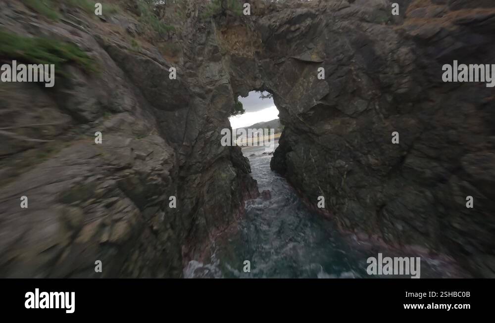 FPV drone flying through a cave with big waves Stock Video Footage - Alamy