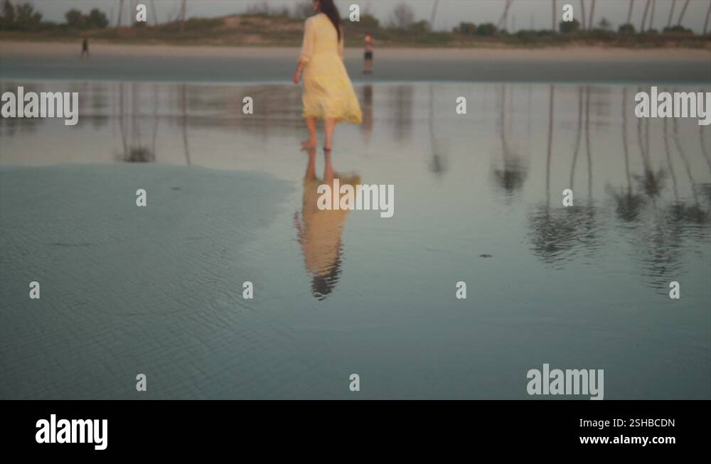 Woman in a yellow dress calmly walking barefoot and swinging her arms at Stock Video Footage - Alamy