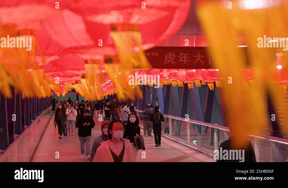 Chinese pedestrians walk through a pedestrian bridge decorated with ...