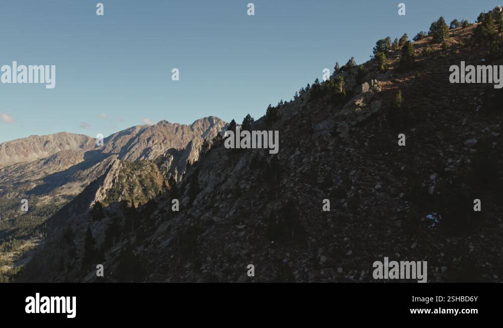 Aerial parallax revealing rocky mountains behind a rocky hill during ...