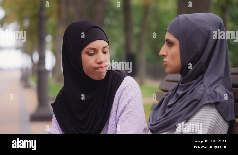 Two arab women in hijabs talking in park, woman comforting best friend ...
