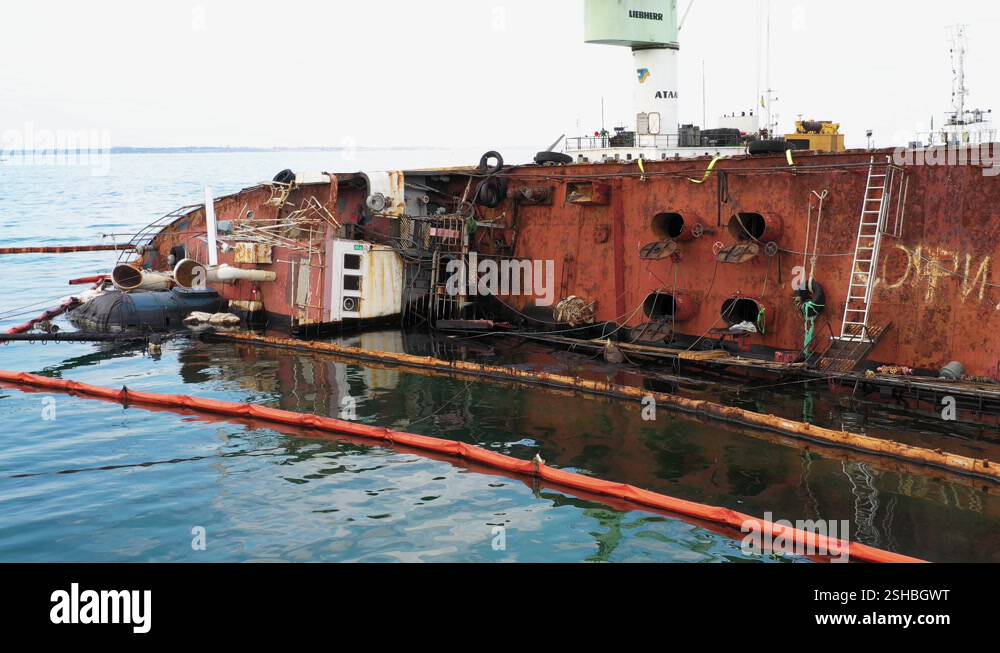 Close up of overturned oil tanker lying on its edge on the shallow ...
