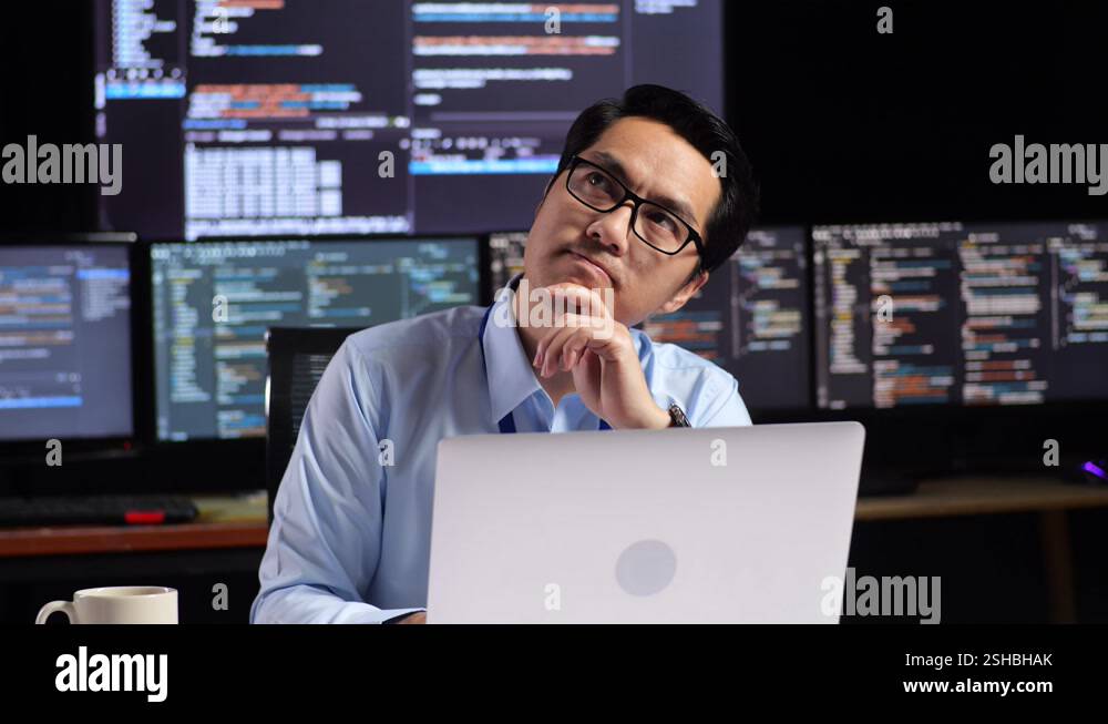 Asian Male Programmer Thinking About Something While Writing Code By A ...