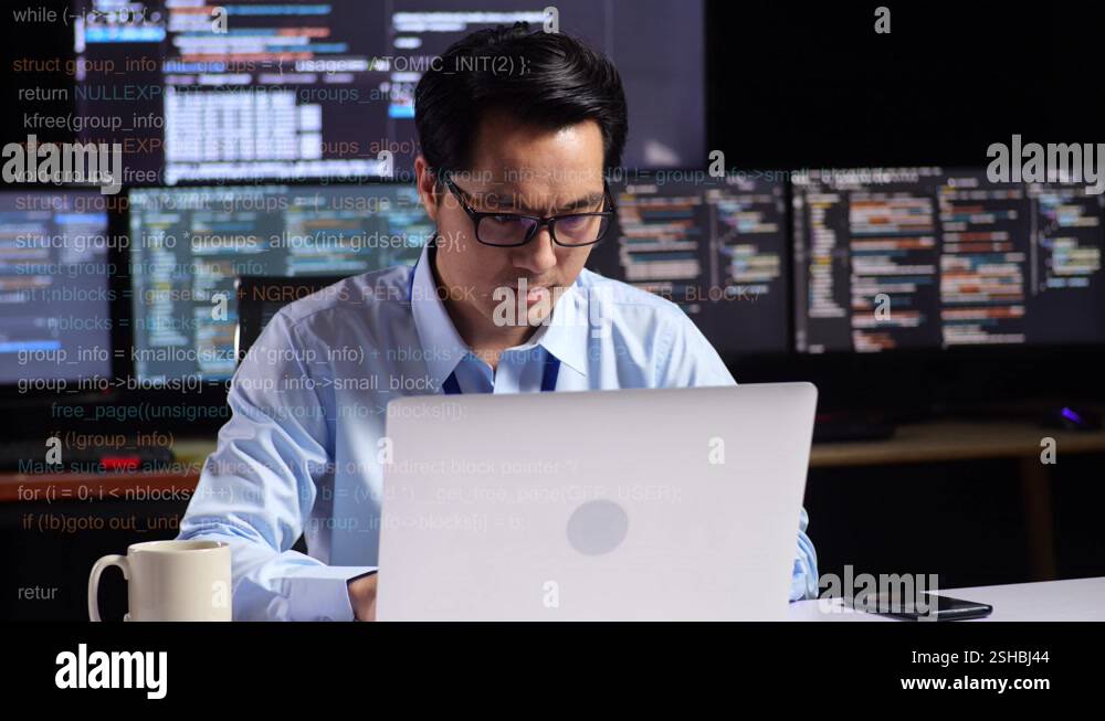 Asian Male Programmer Writing Code By A Laptop Using Multiple Monitors Showing Stock Video ...